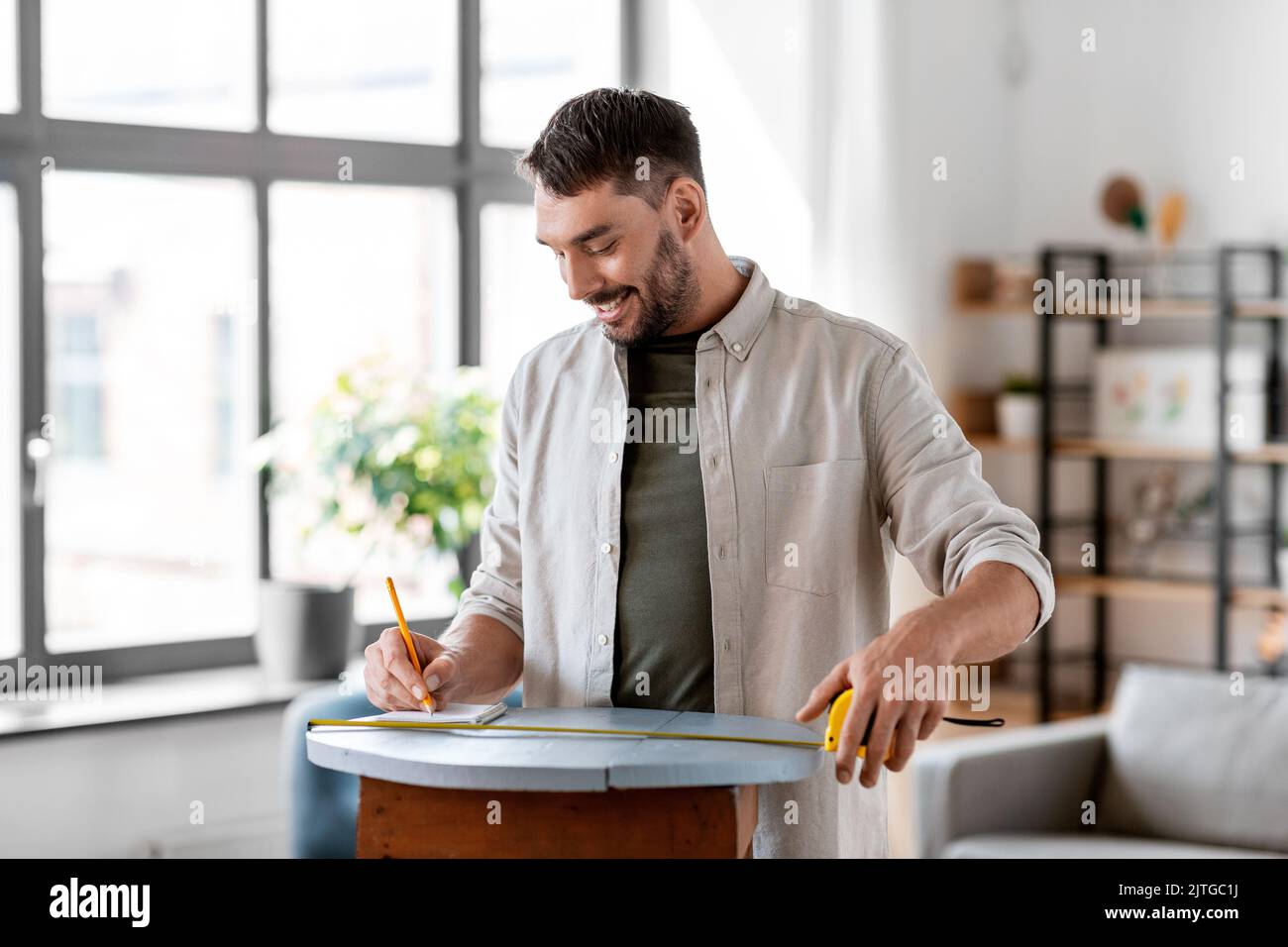 man with ruler measuring table for renovation Stock Photo - Alamy