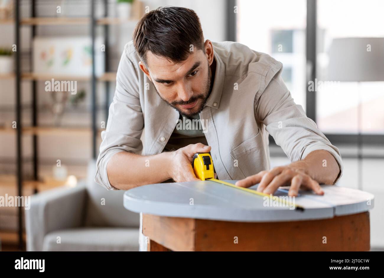 man with ruler measuring table for renovation Stock Photo - Alamy