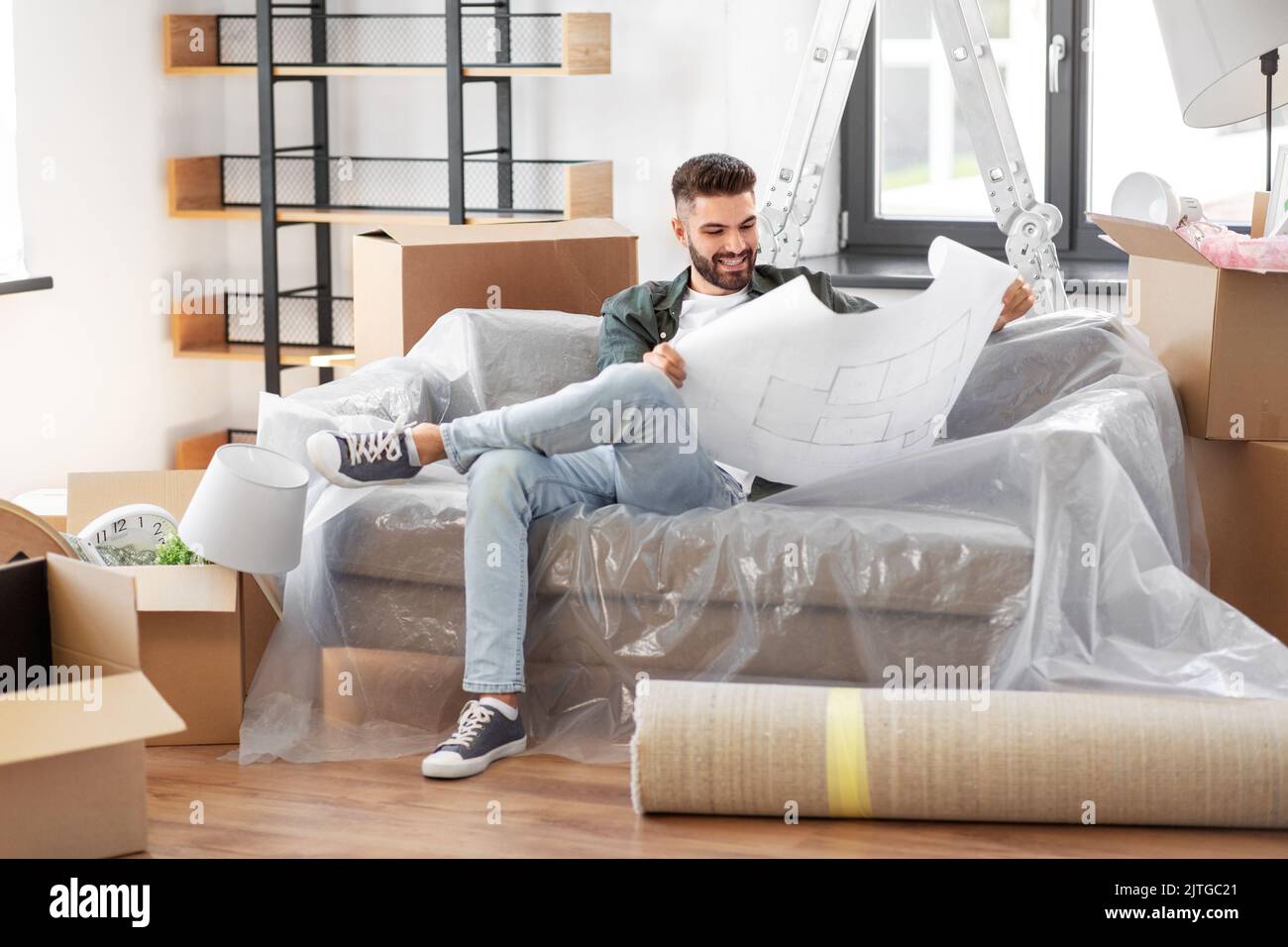 happy man with blueprint moving to new home Stock Photo - Alamy
