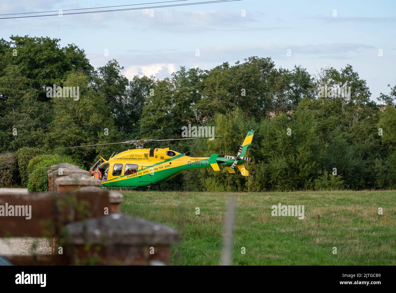 Wiltshire Air Ambulance preparing to take off from a grass field Stock ...