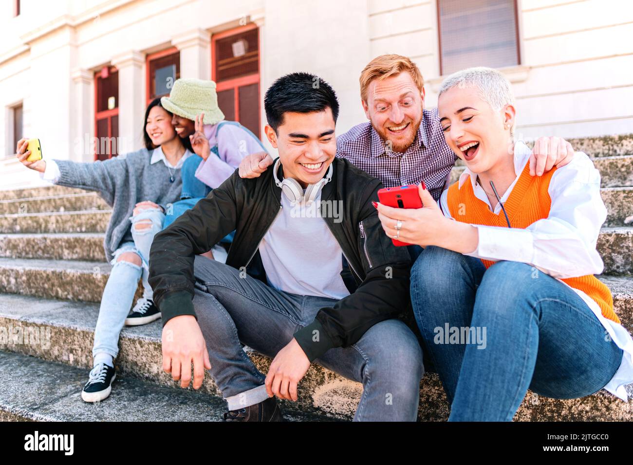 Group of young multiethnic friends watching media with a smartphone ...