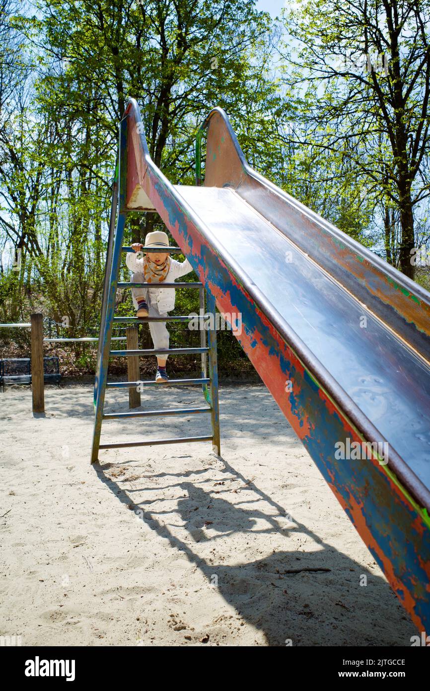 Child climbing up slide hi-res stock photography and images - Alamy