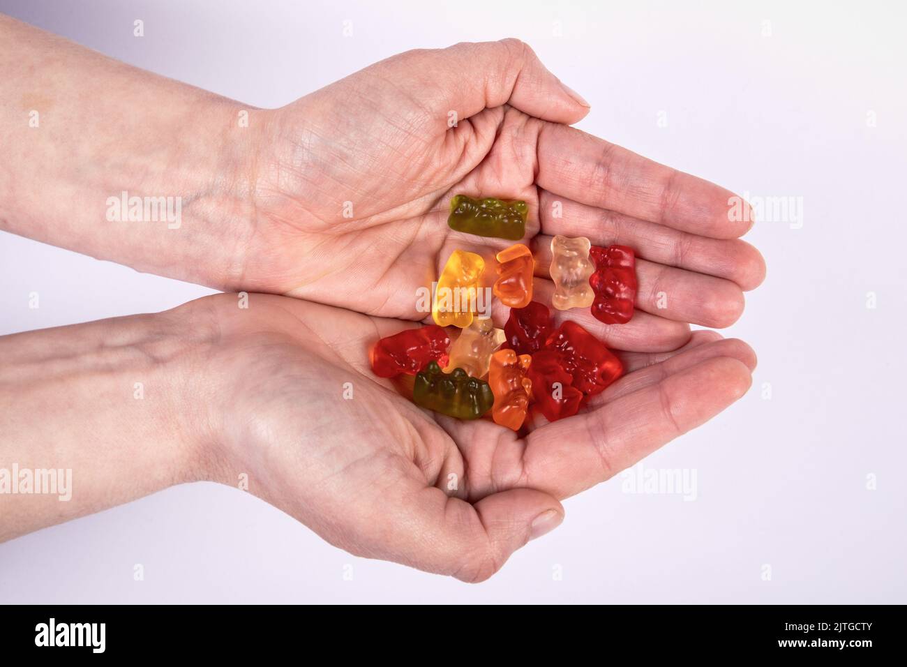 Gummy bear candies in the hands of a woman Stock Photo - Alamy