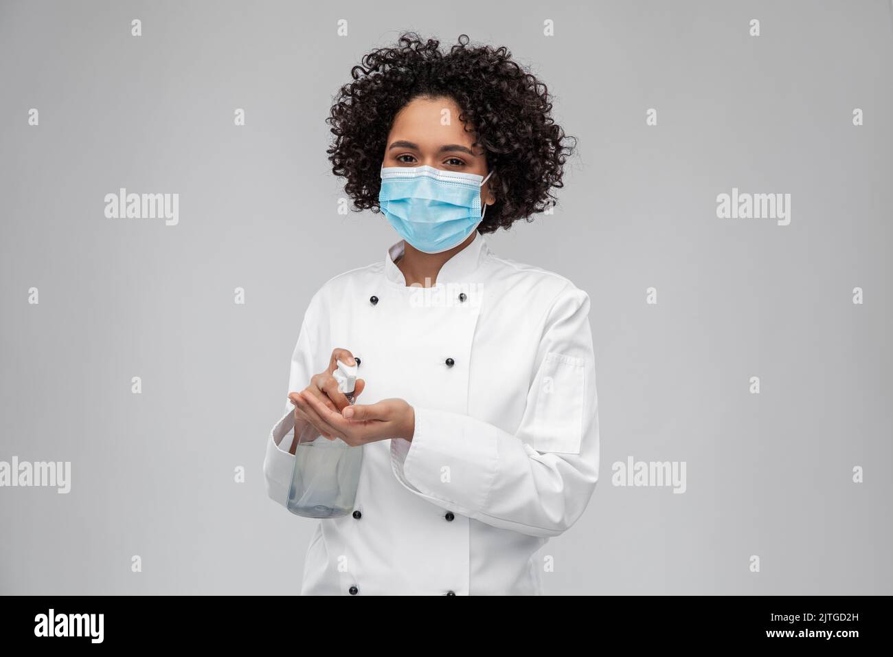 female chef in mask using hand sanitizer or soap Stock Photo - Alamy