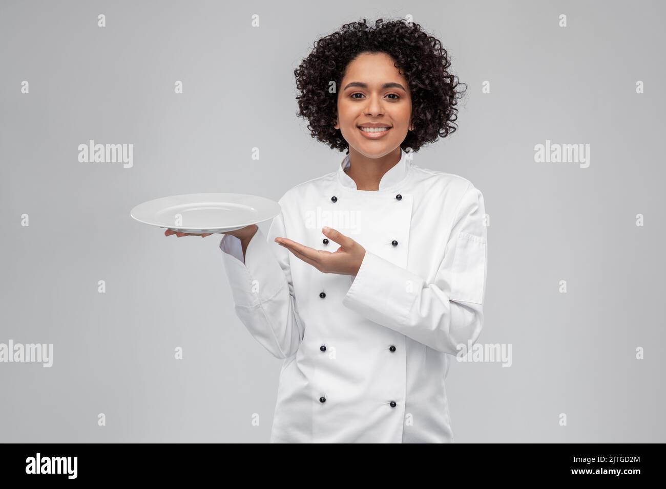 happy smiling female chef holding empty plate Stock Photo - Alamy