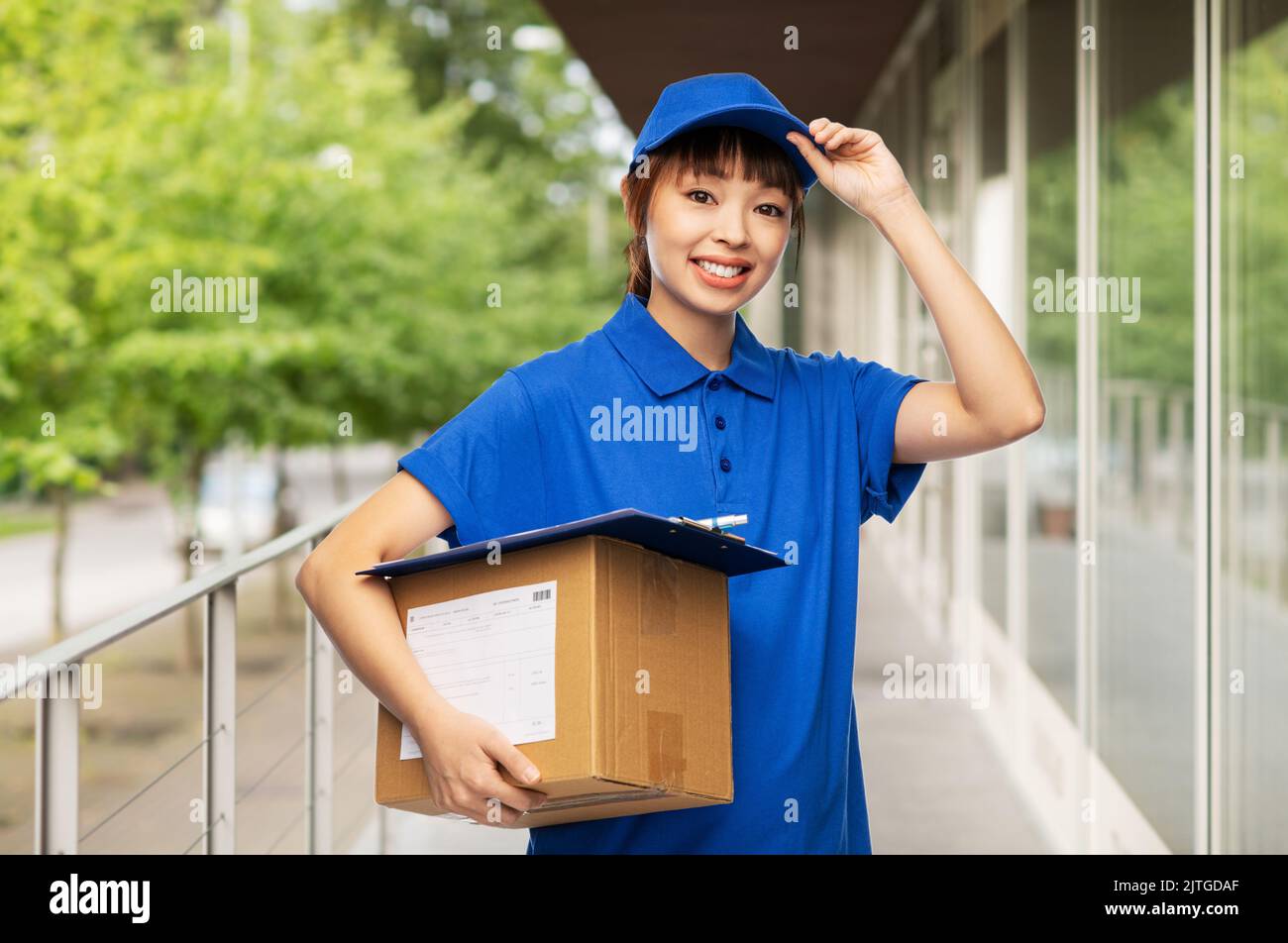 happy smiling delivery woman holding parcel box Stock Photo - Alamy