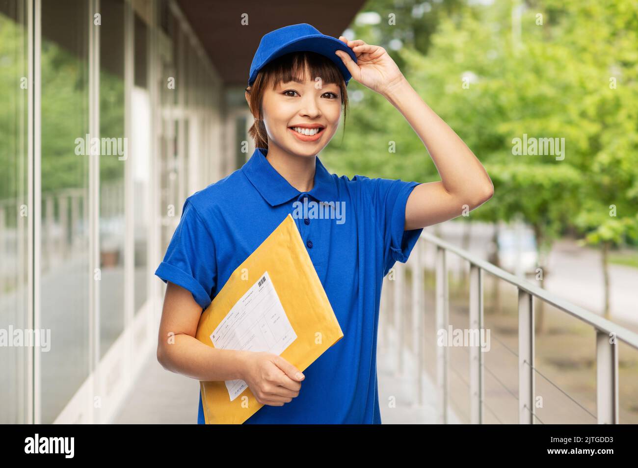 happy delivery woman holding parcel envelope Stock Photo - Alamy