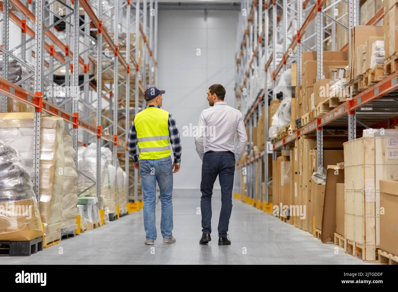 worker and businessman walking along warehouse Stock Photo - Alamy