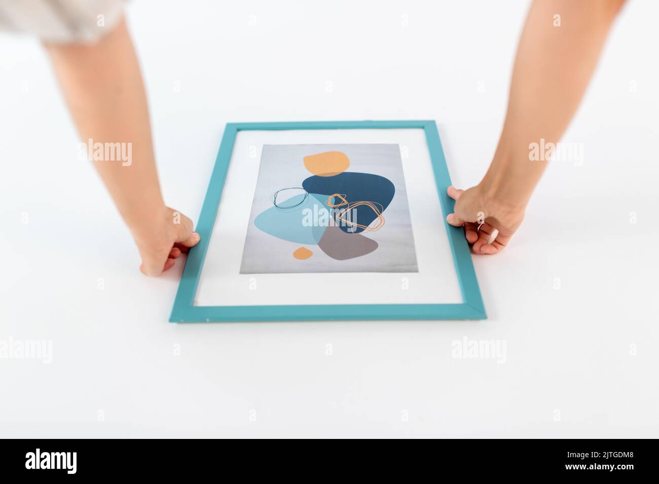 close up of hands hanging picture in frame on wall Stock Photo - Alamy