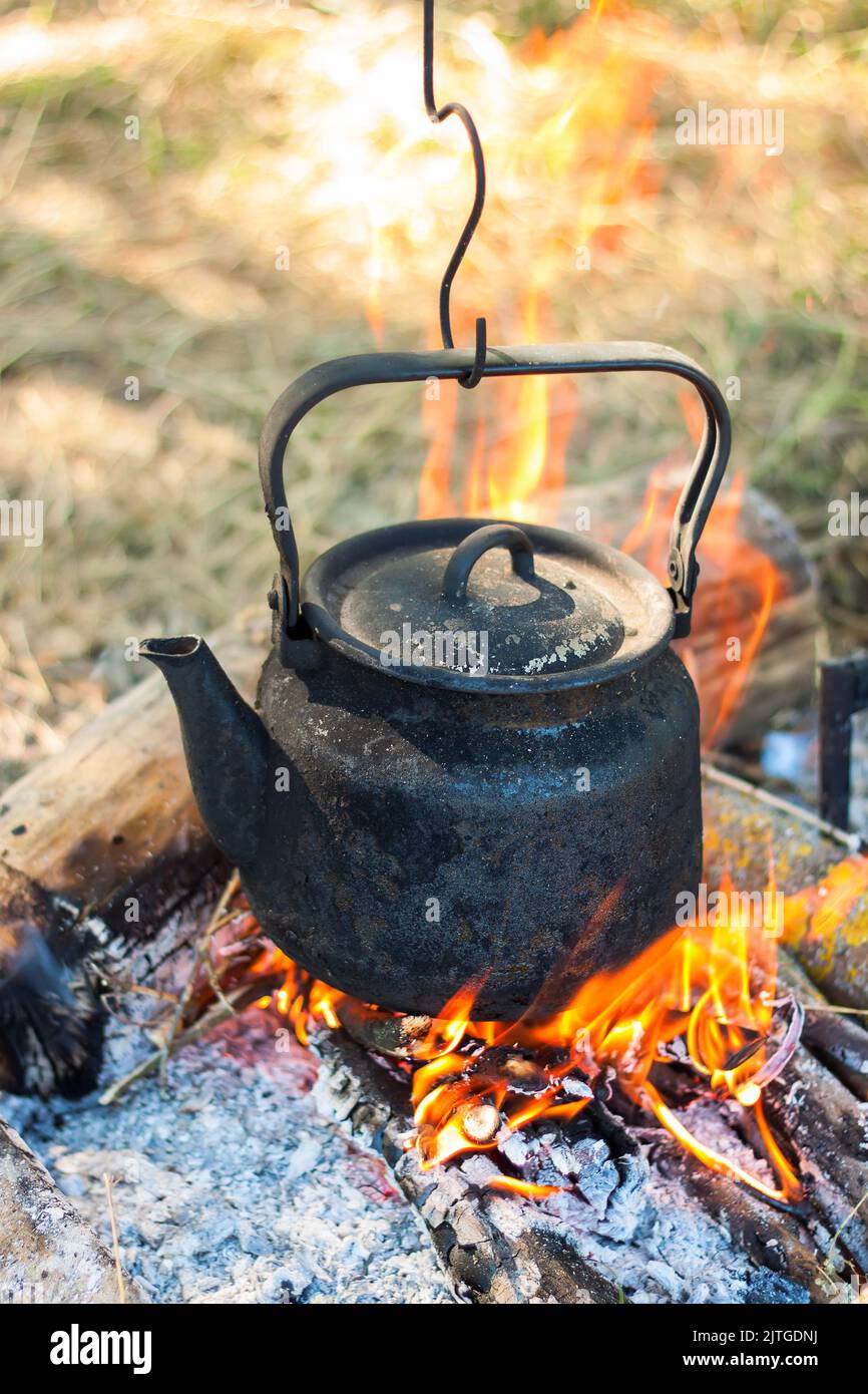 Smoked tourist kettle over camp fire. Process of cooking on the nature ...