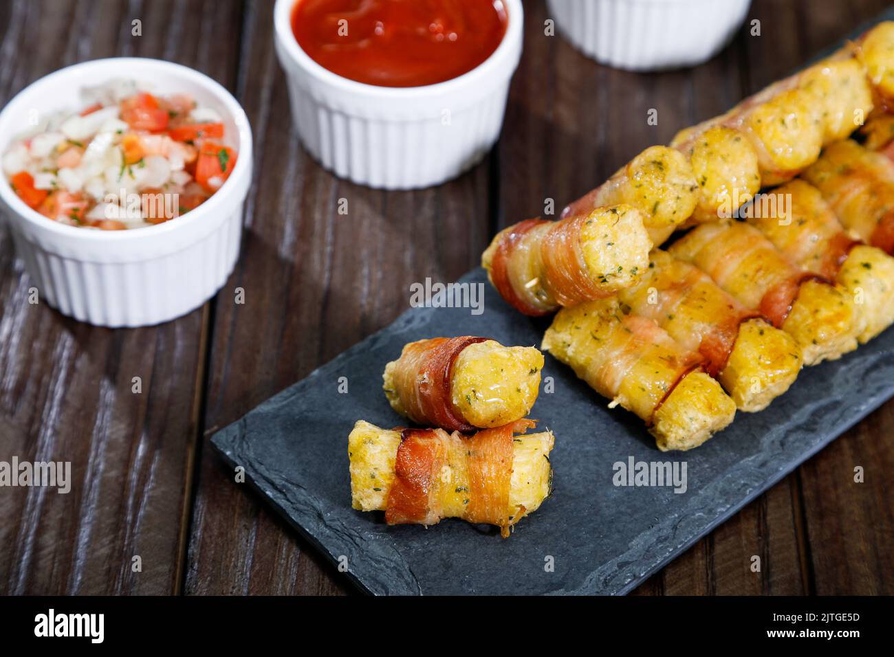 Cassava skewers wrapped in bacon, cassava medallion Stock Photo - Alamy