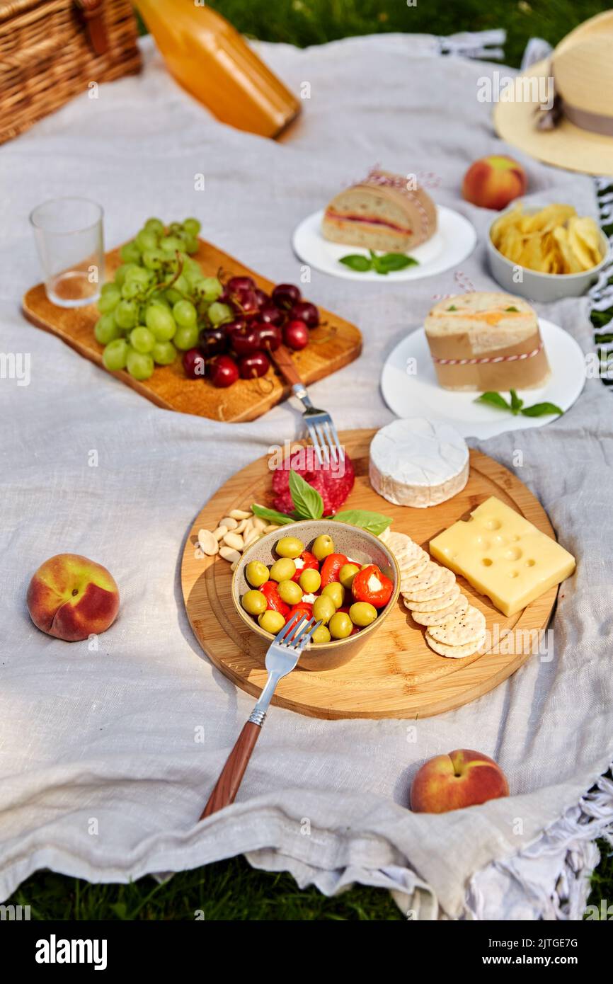 food, drinks and picnic basket on blanket on grass Stock Photo - Alamy