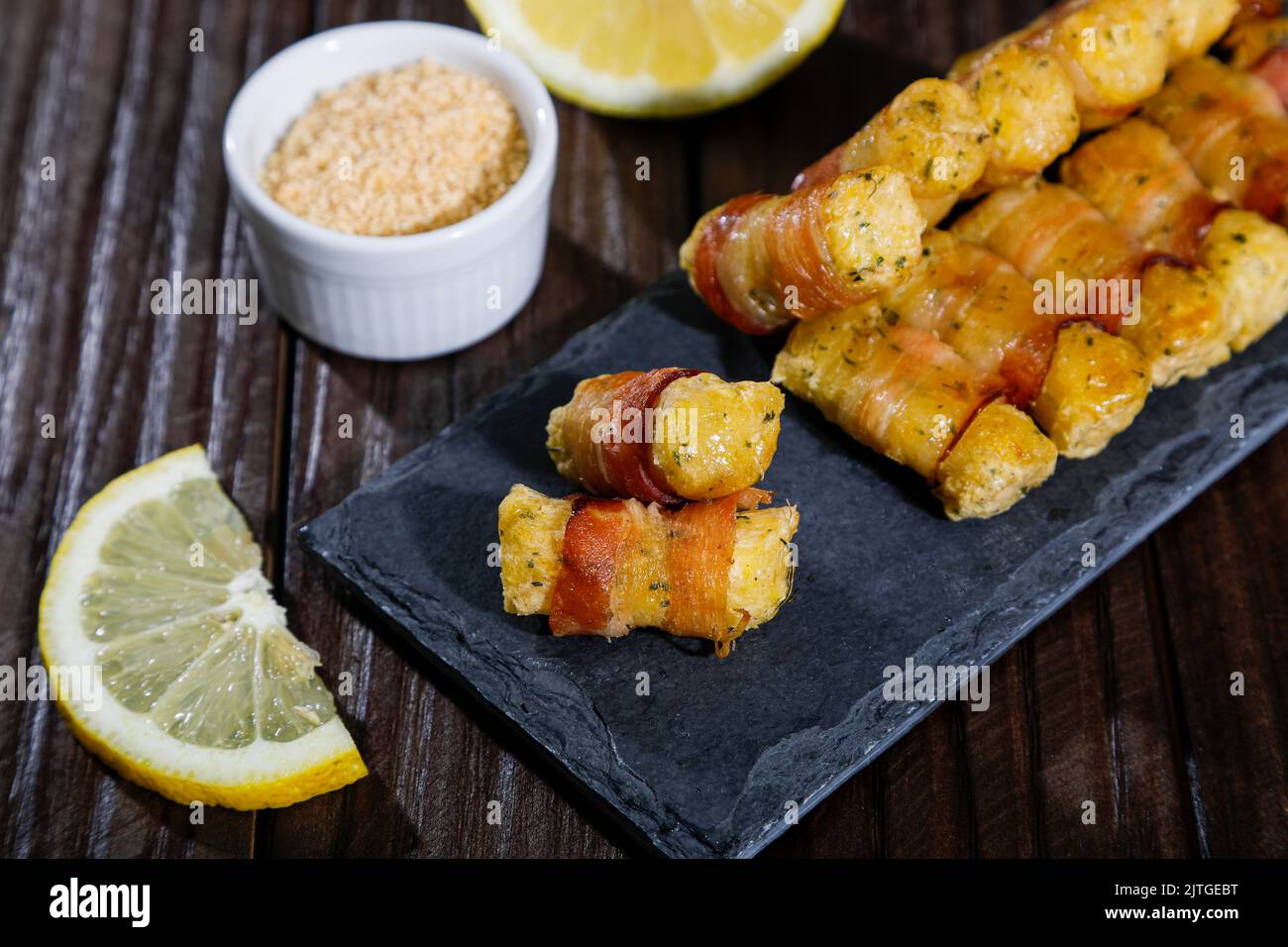 Cassava skewers wrapped in bacon, cassava medallion Stock Photo - Alamy