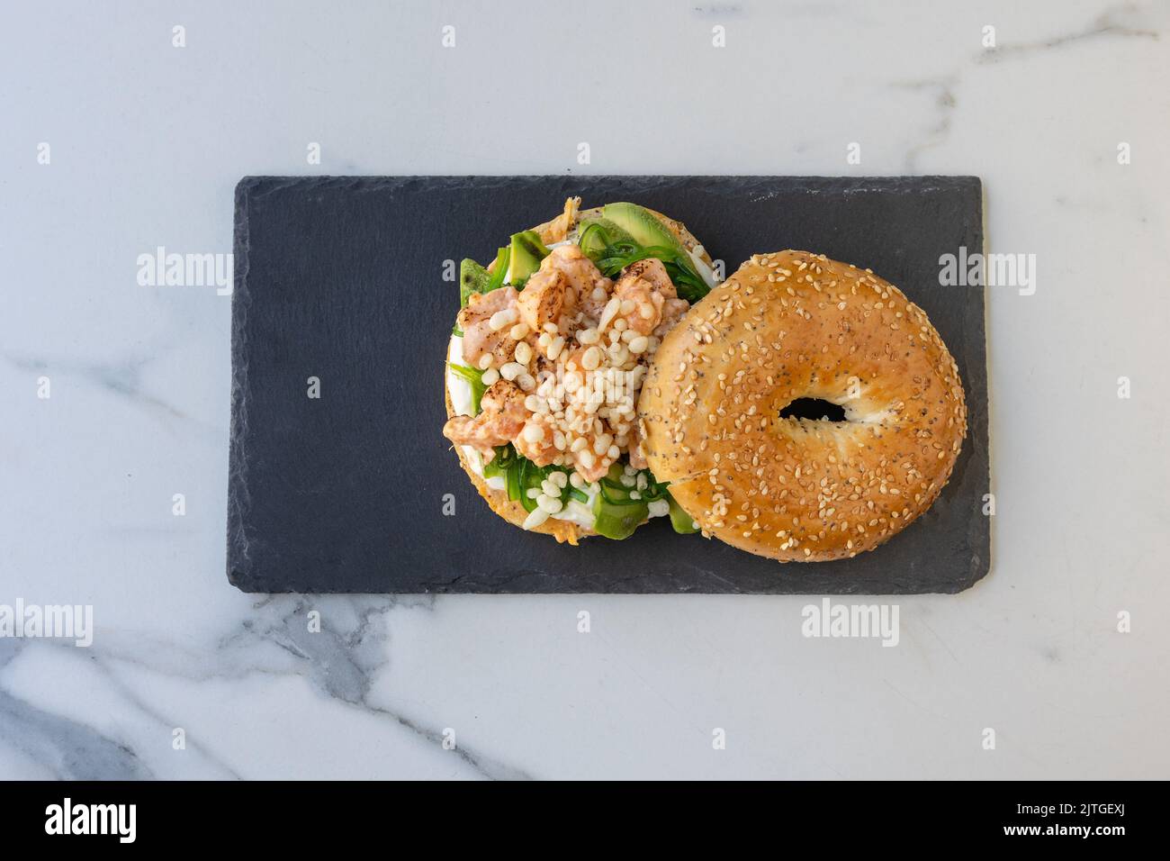 A top view of an open cut bagel with delicious meat, vegetables, and ...