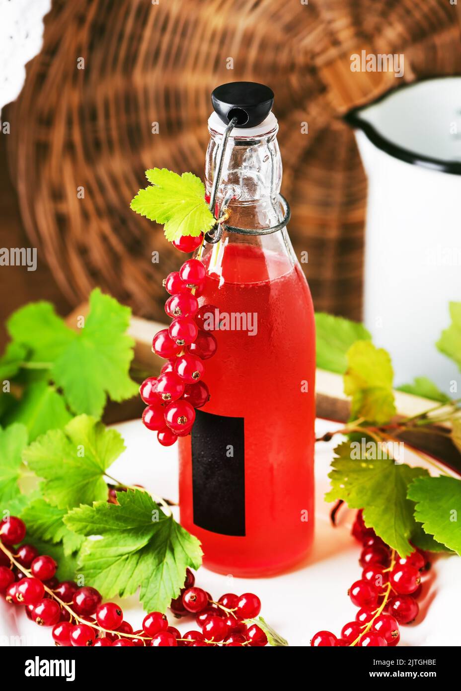 Healthy homemade red currant syrup in a glass bottle for cold summer ...