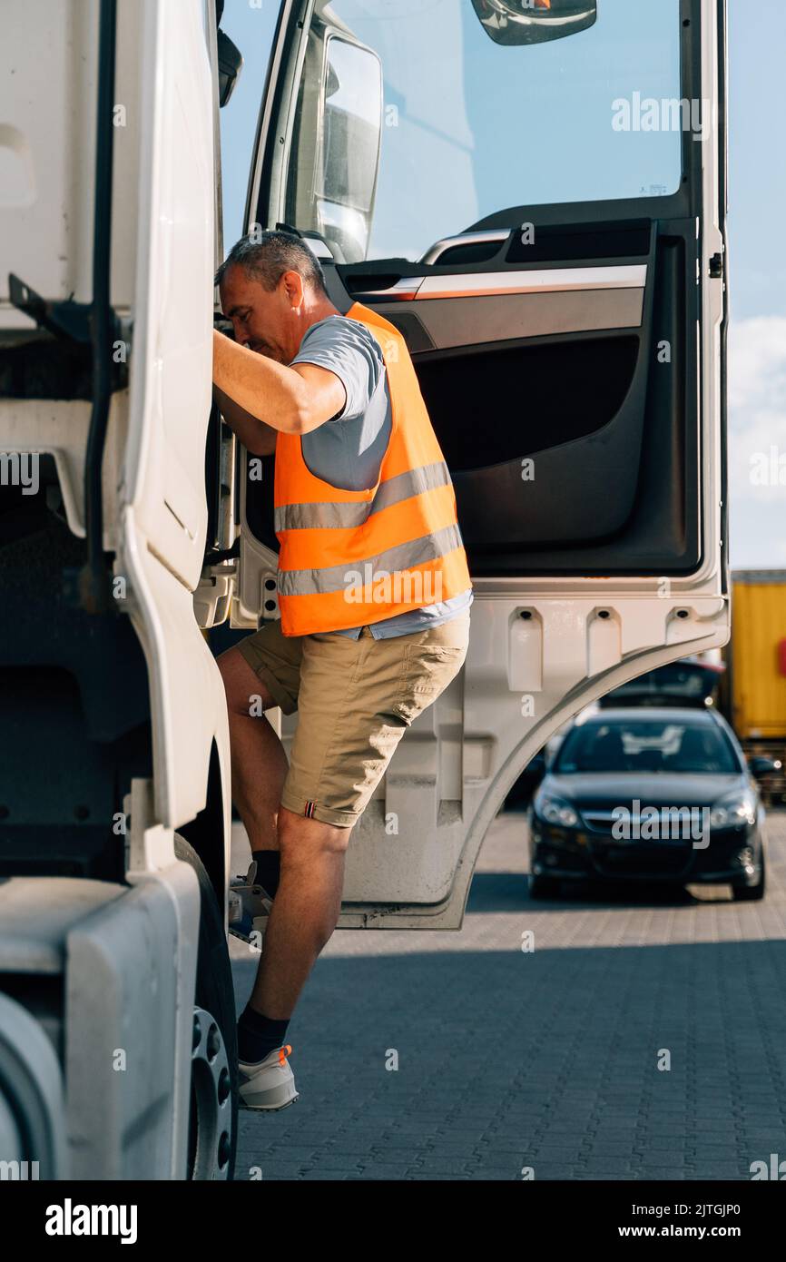 Portrait of caucasian mature man on semi-truck vehicles parking ...