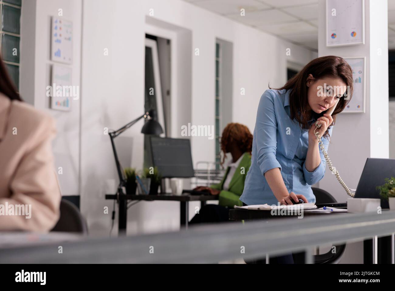 Office manager discussing management strategy on landline phone ...