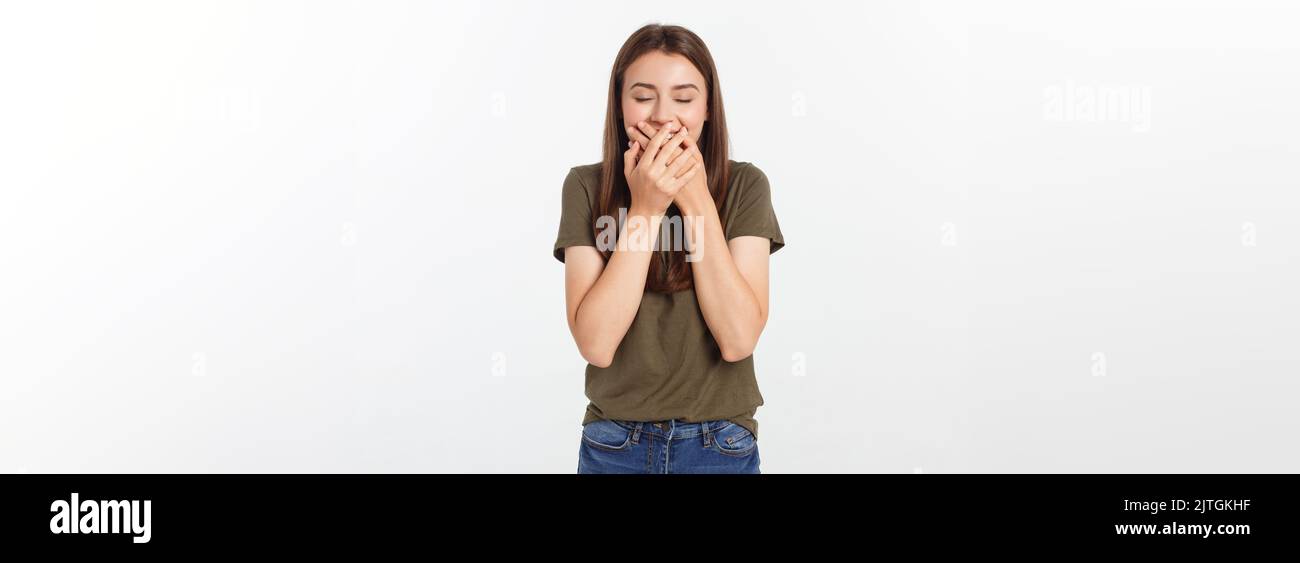 Happy woman laughing covering her mouth with a hands isolate over grey ...