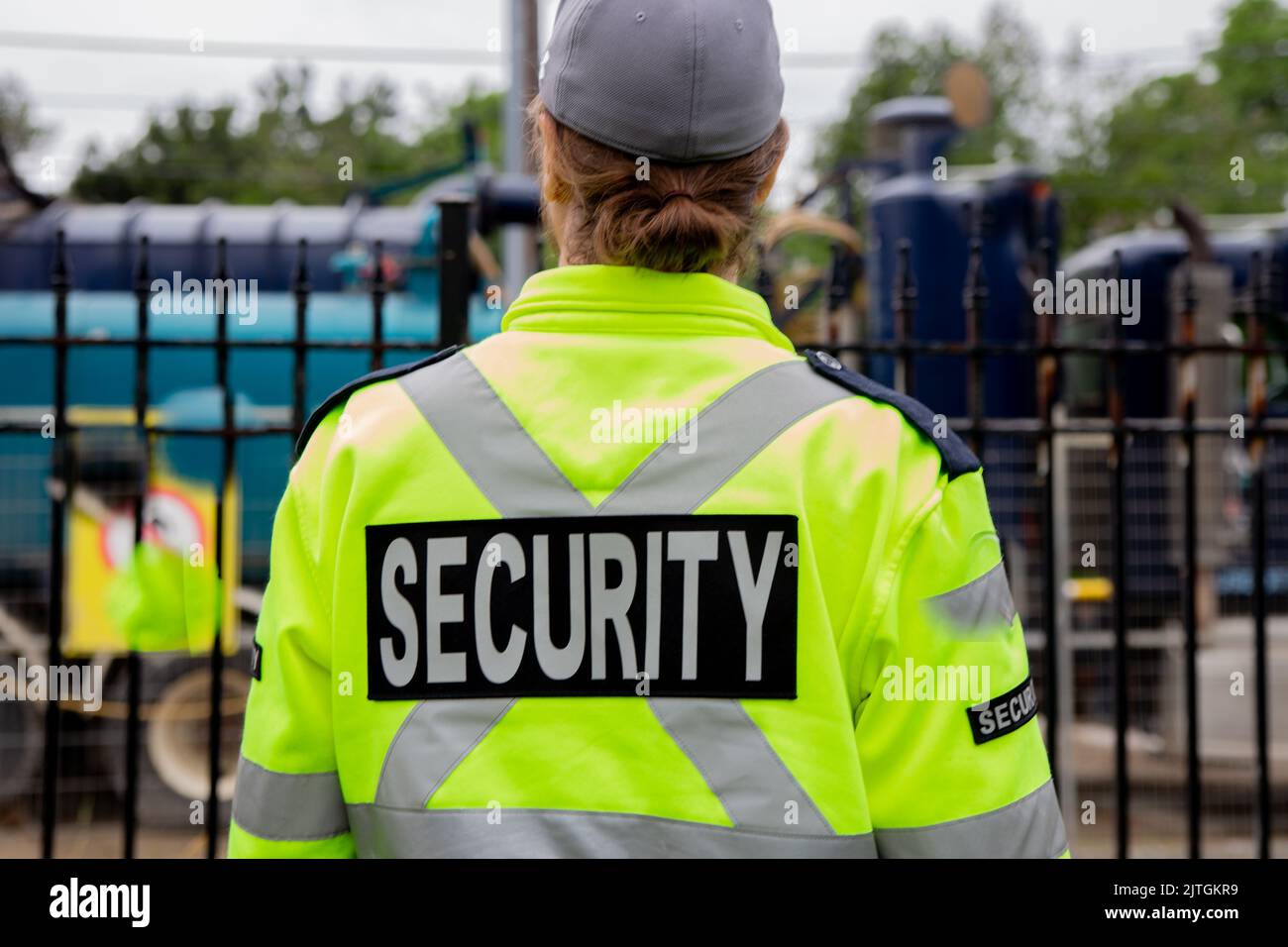 A closeup back shot of a security guard patrolling the street next to ...