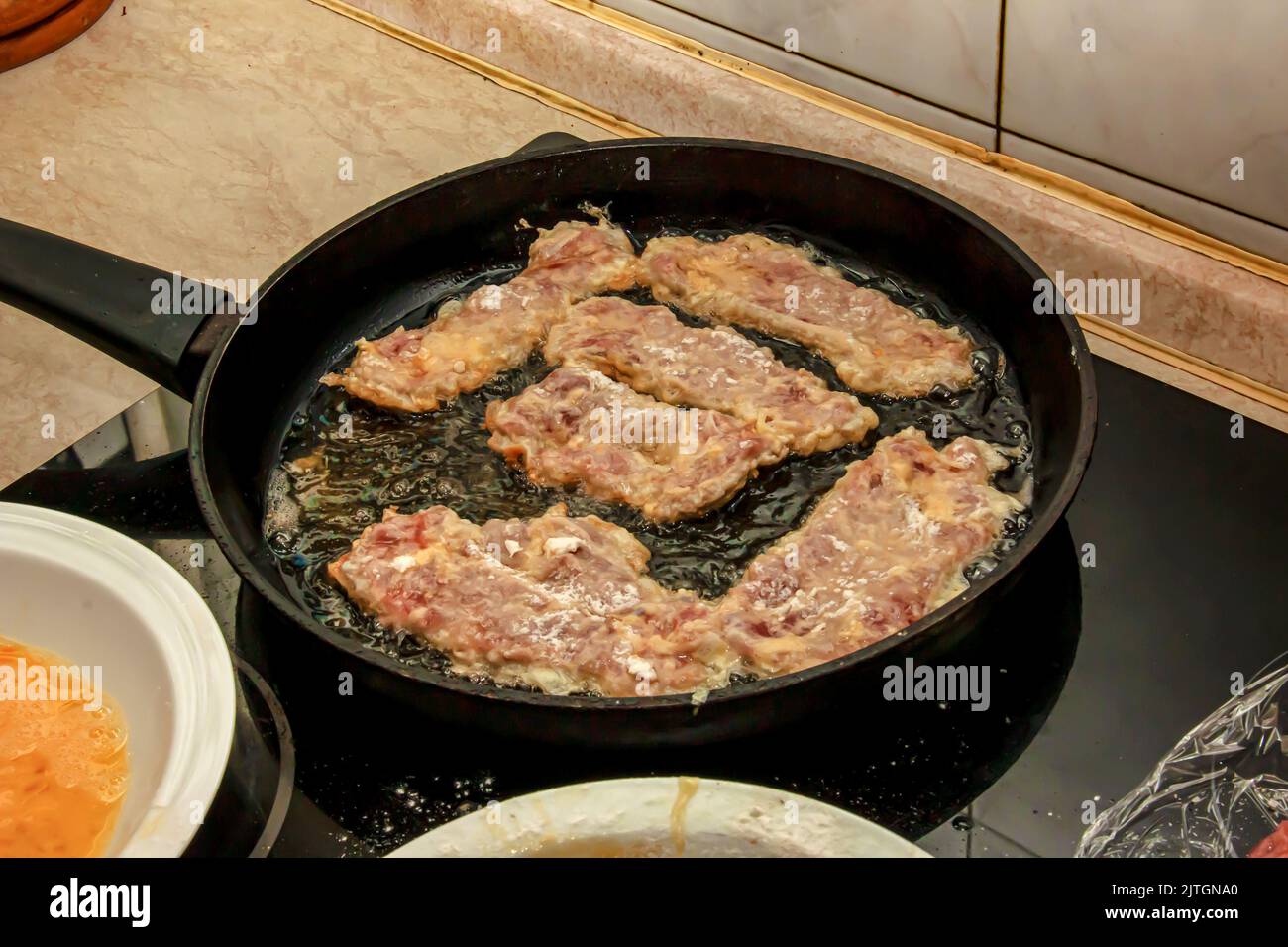 Beef chops in a pan on the stove. The process of preparing beef chops ...