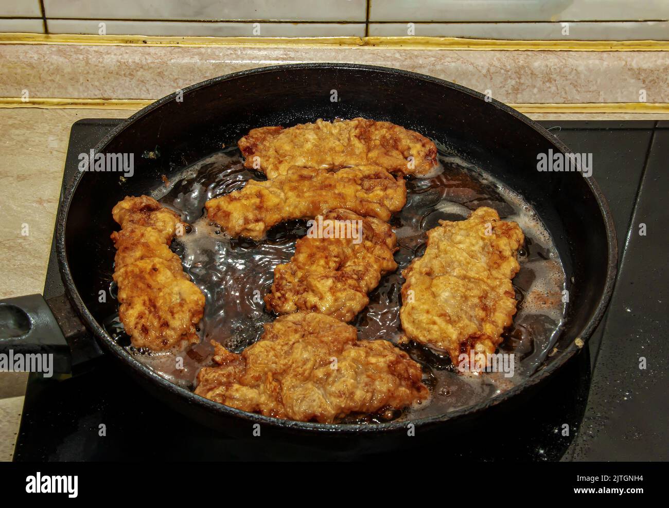 Beef chops in a pan on the stove. The process of preparing beef chops ...