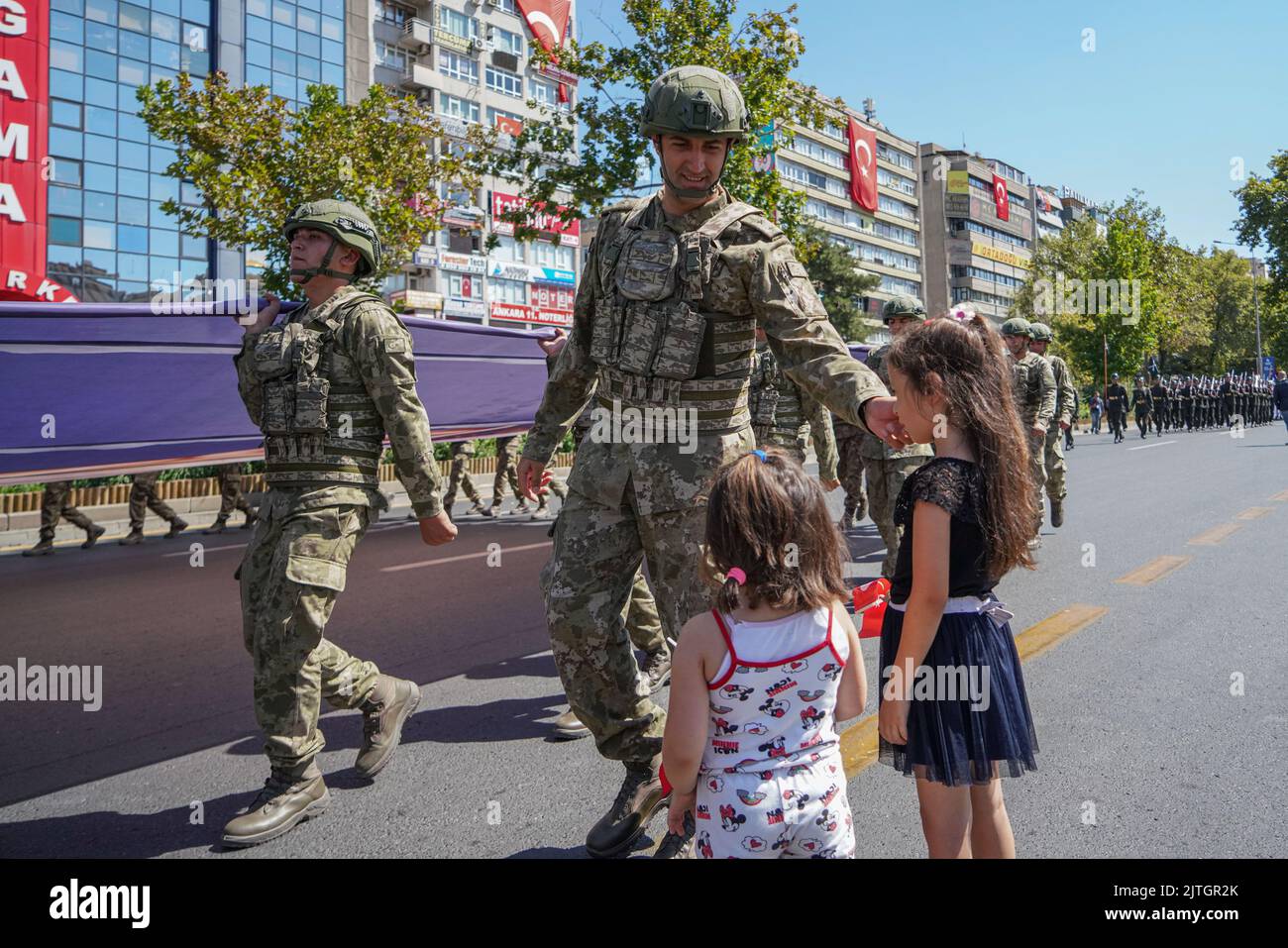 A Turkish soldier greets a young girl who salutes him during the ...