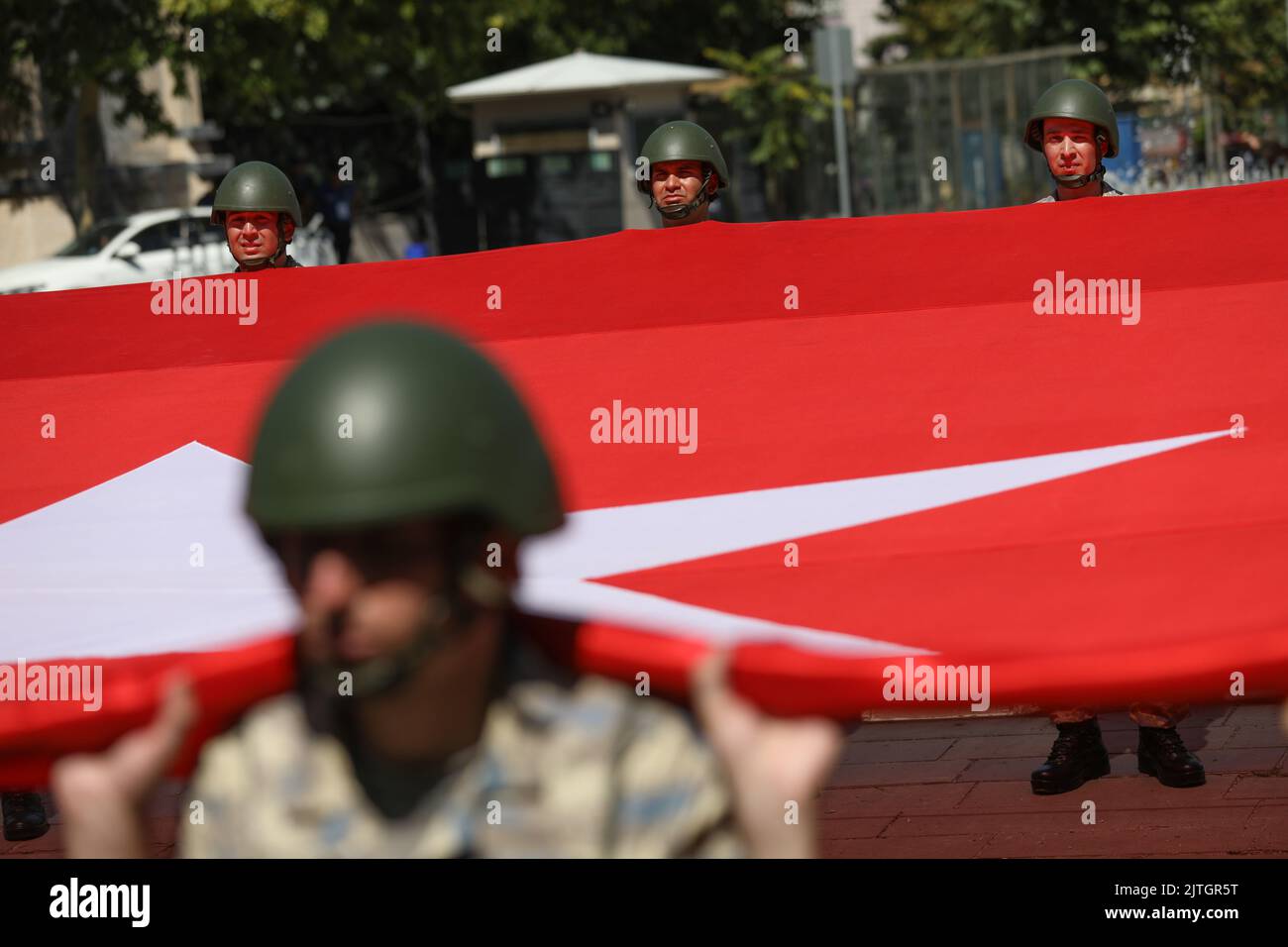 Turkish soldiers march with a Turkish flag during the military parade ...