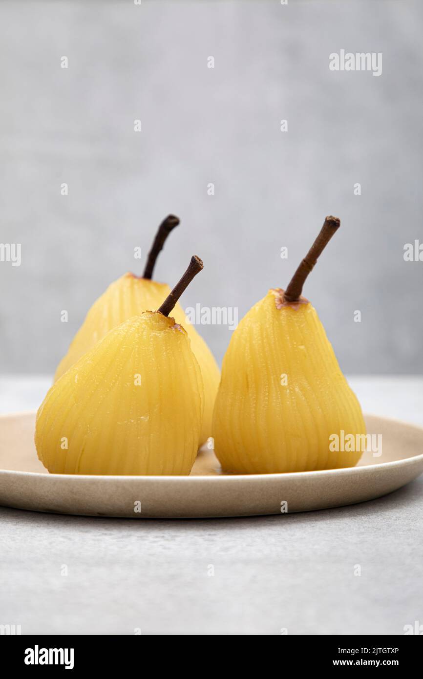 Poached Pears with skin removed and served on a plate Stock Photo - Alamy