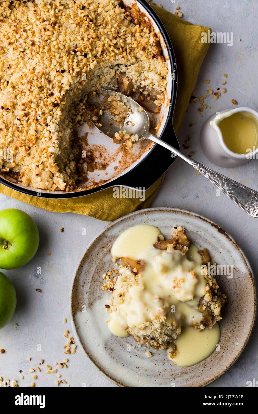 Apple crumble and custard dessert Stock Photo - Alamy