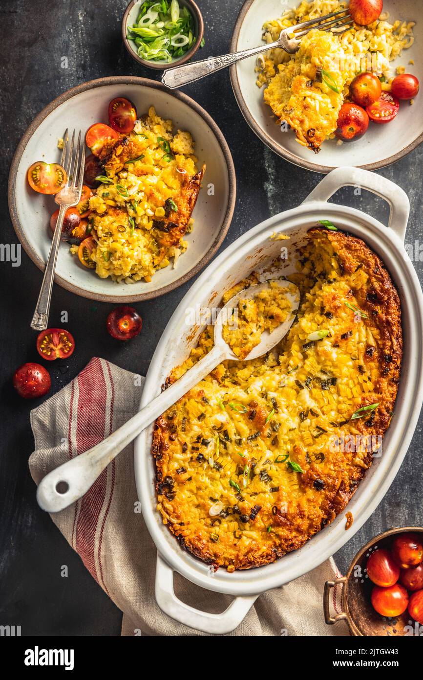 Cheddar Corn Pudding in casserole and serving dishes with cherry ...