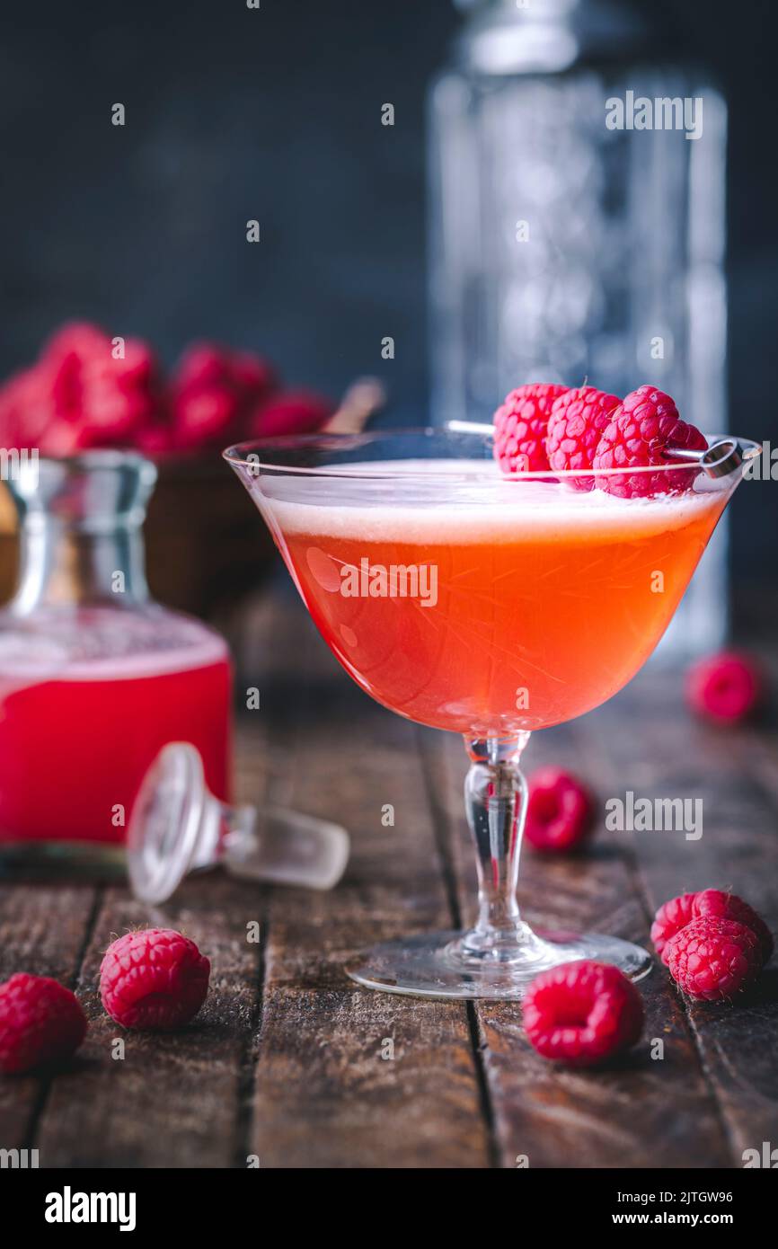 Side angle of Raspberry Cocktail in vintage glass with fresh raspberry ...