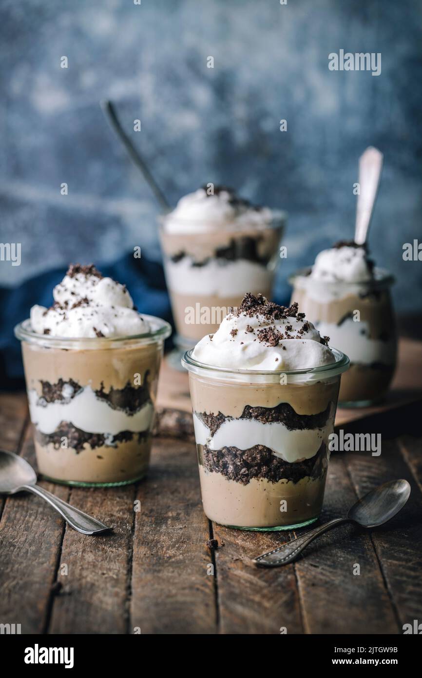 Chocolate cookies, custard and whipped cream layered parfaits in clear ...