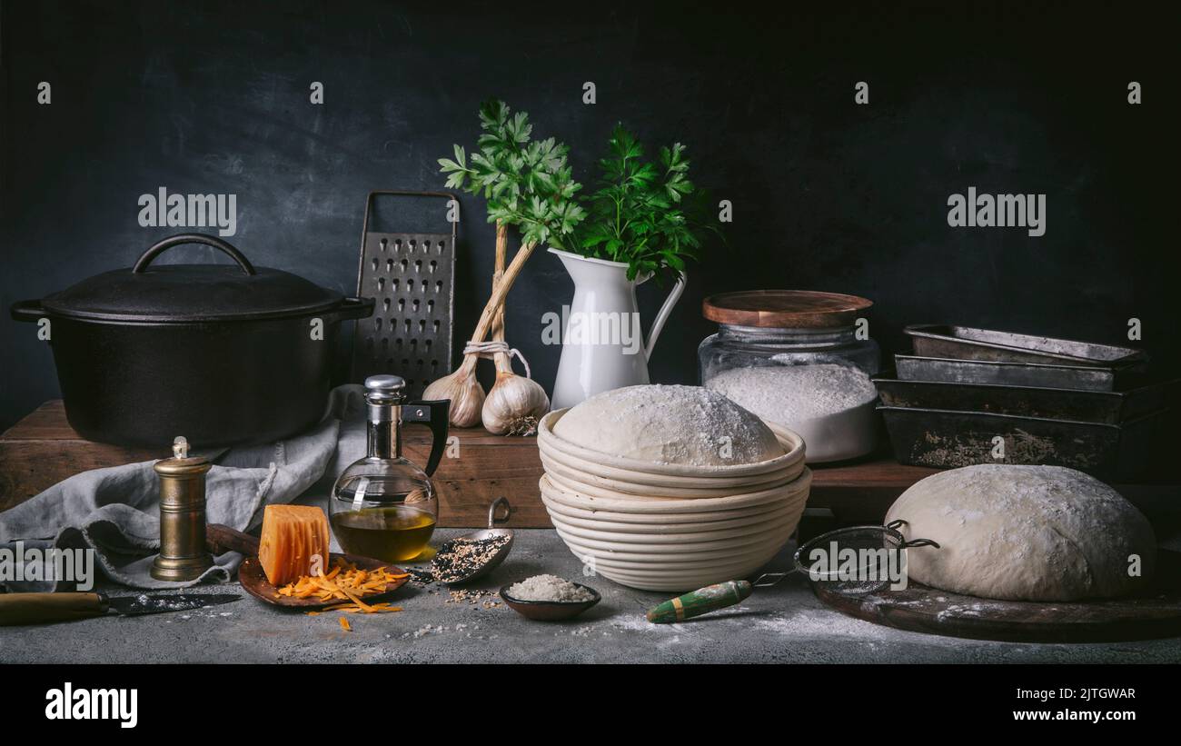 Still life arrangement with rising bread dough, olive oil, cheese and ...