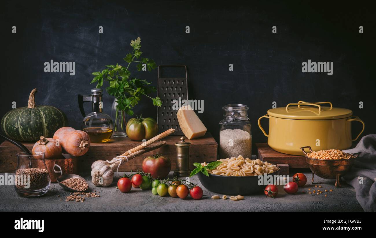 Still life arrangement with pasta, tomatoes, garlic, Parmesan and ...