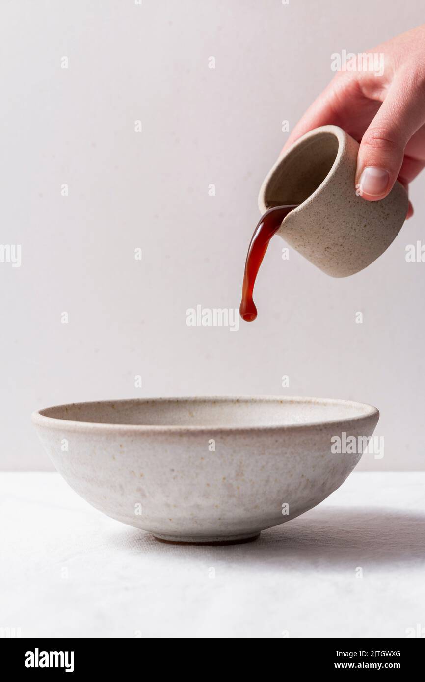 Hand pouring jug of coffee into a ceramic bowl Stock Photo - Alamy