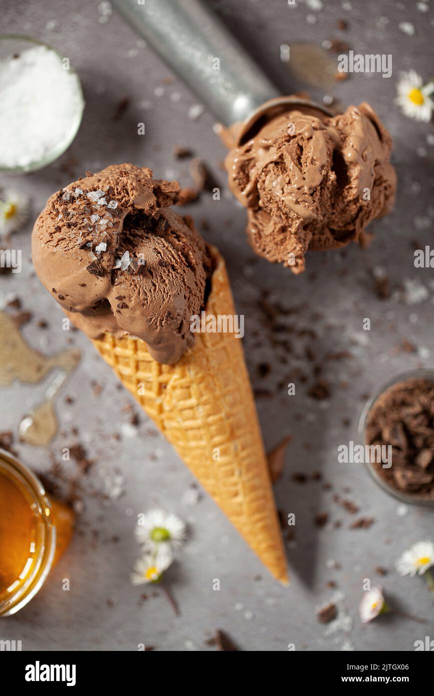 Chocolate ice cream scooped into a waffe cone and topped with dark ...