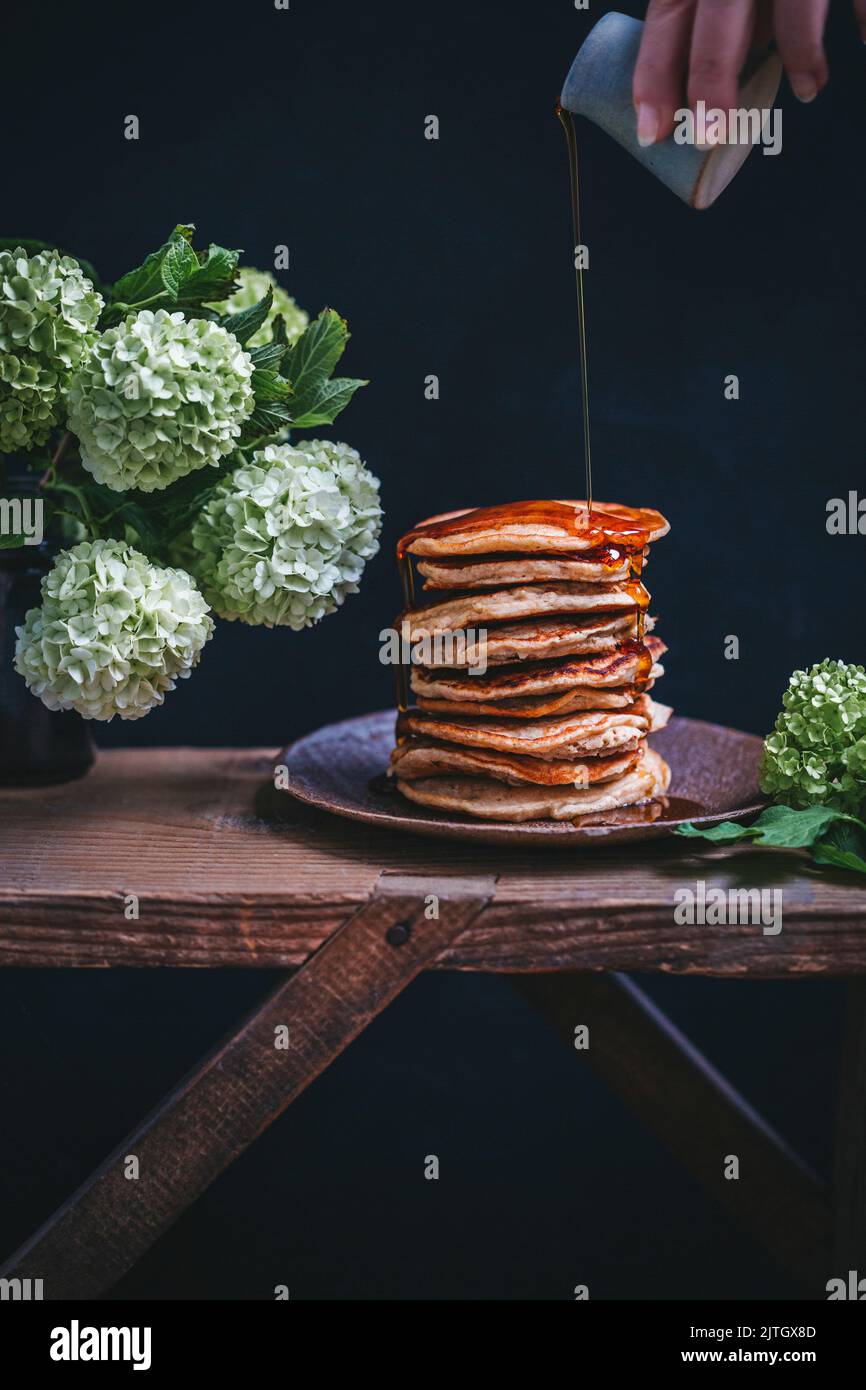 Maple syrup poured on top of pancakes stack Stock Photo - Alamy