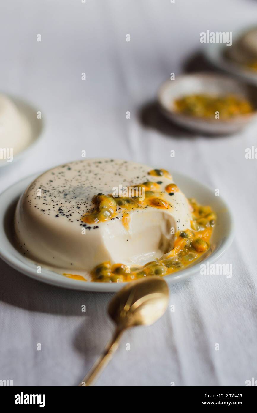 Passionfruit panna cotta with spoonfull removed Stock Photo - Alamy
