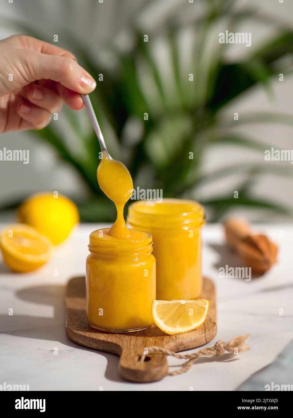 Delicious homemade lemon curd. Glass jar with lemon curd and full spoon ...
