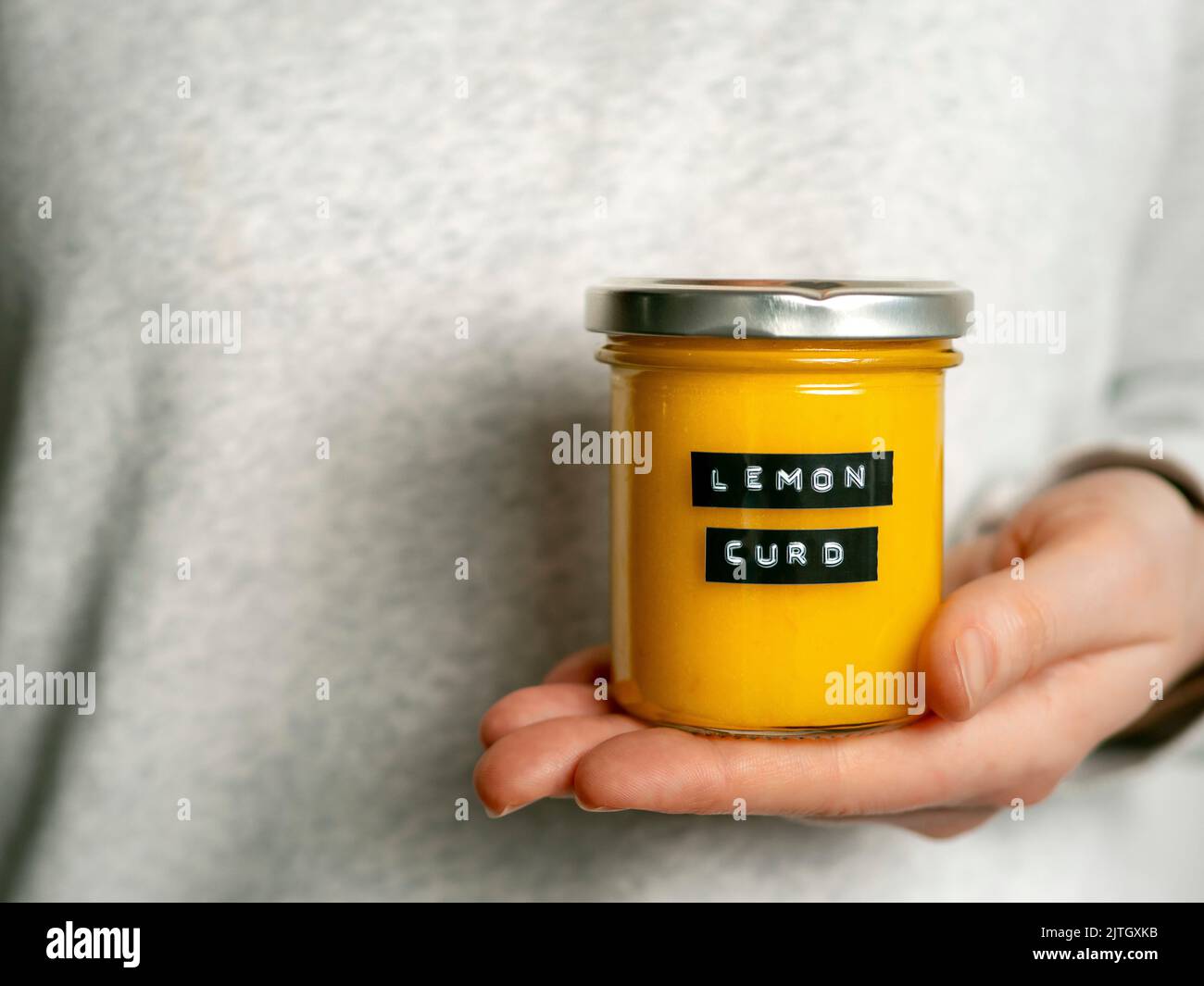 Female hand holds glass jar with delicious homemade lemon curd. Black ...
