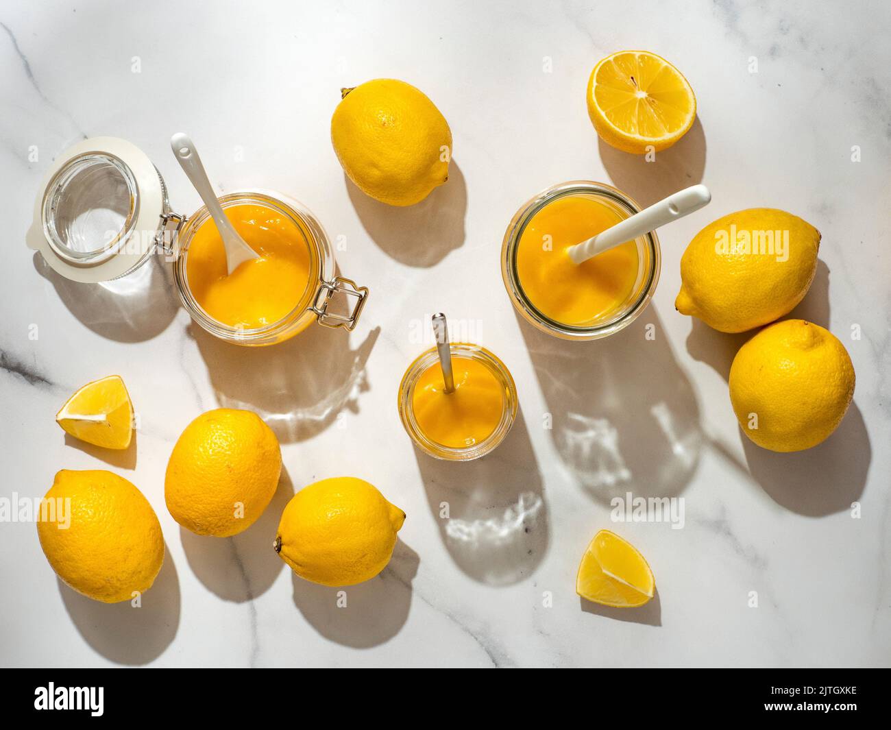 Delicious homemade lemon curd. Top view of open glass jars with lemon ...