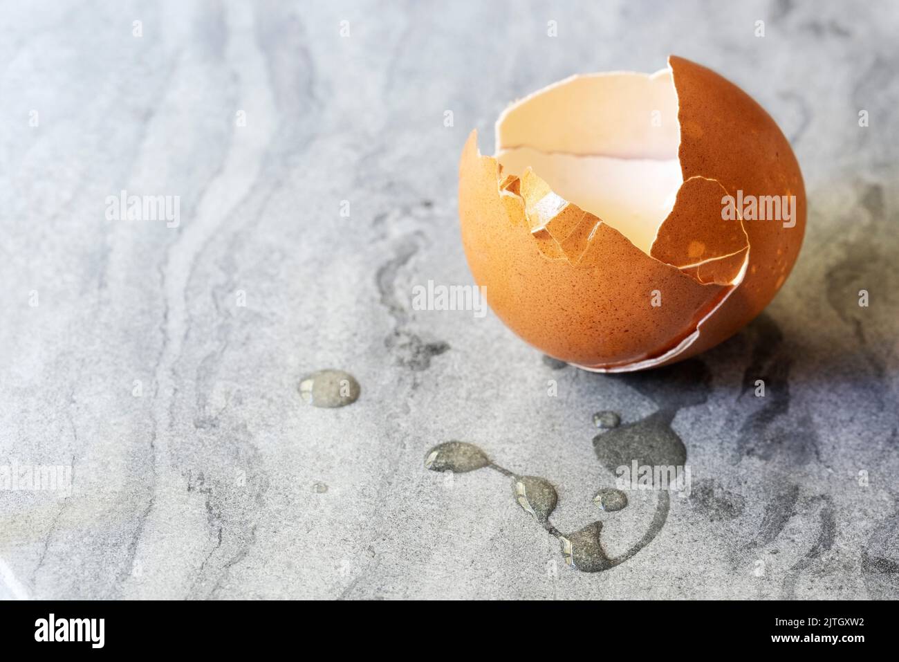 A cracked eggshell with eggwhite on a marble surface Stock Photo - Alamy