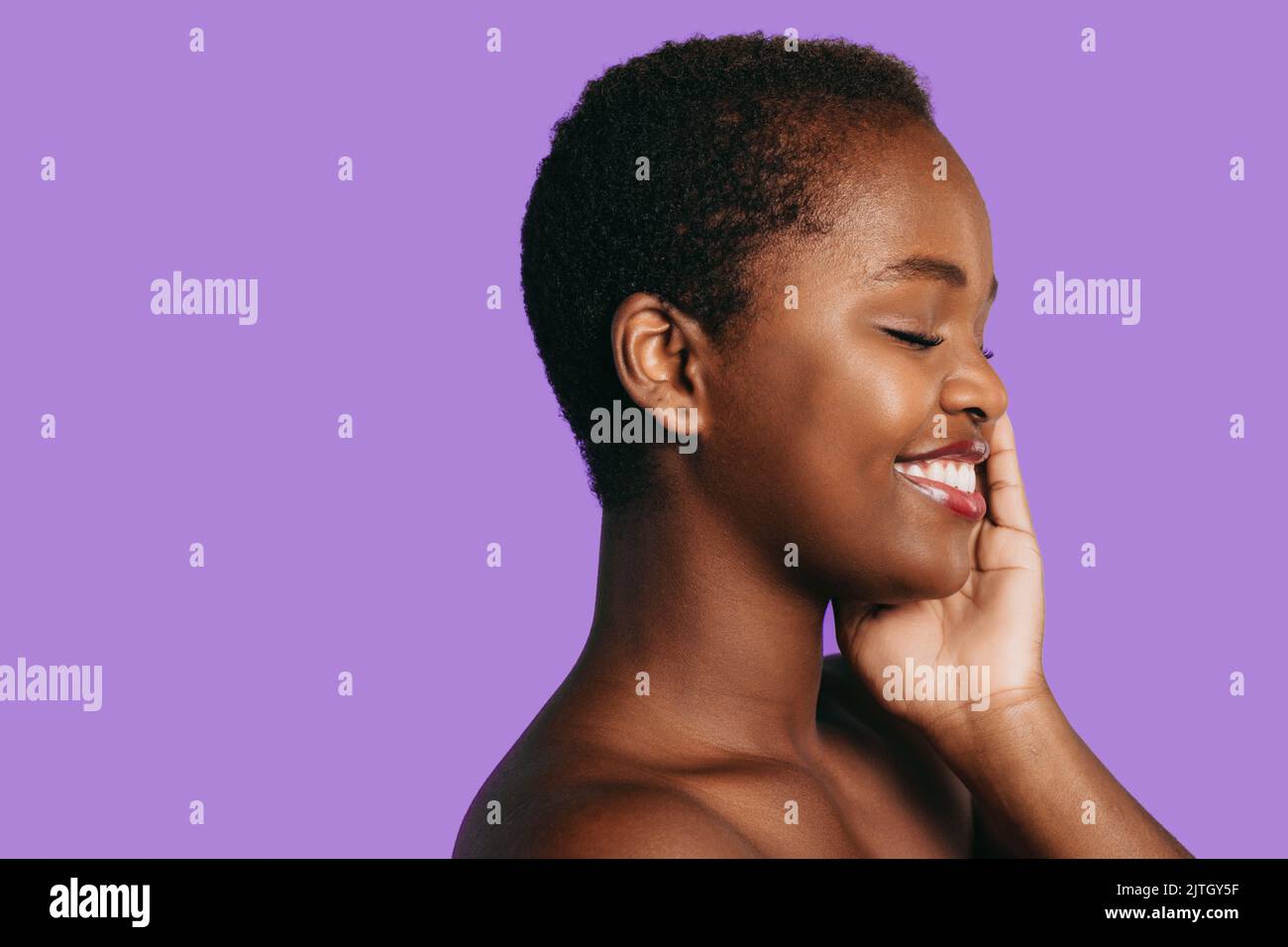 Close-up portrait of African woman, holding hand on cheek isolated over ...