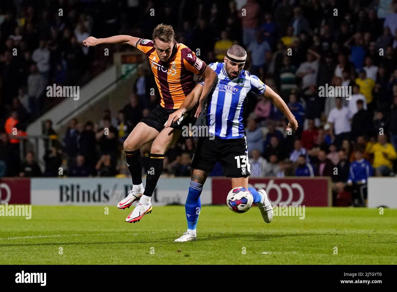 Richard Smallwood #6 of Bradford City competes for the ball with Callum ...