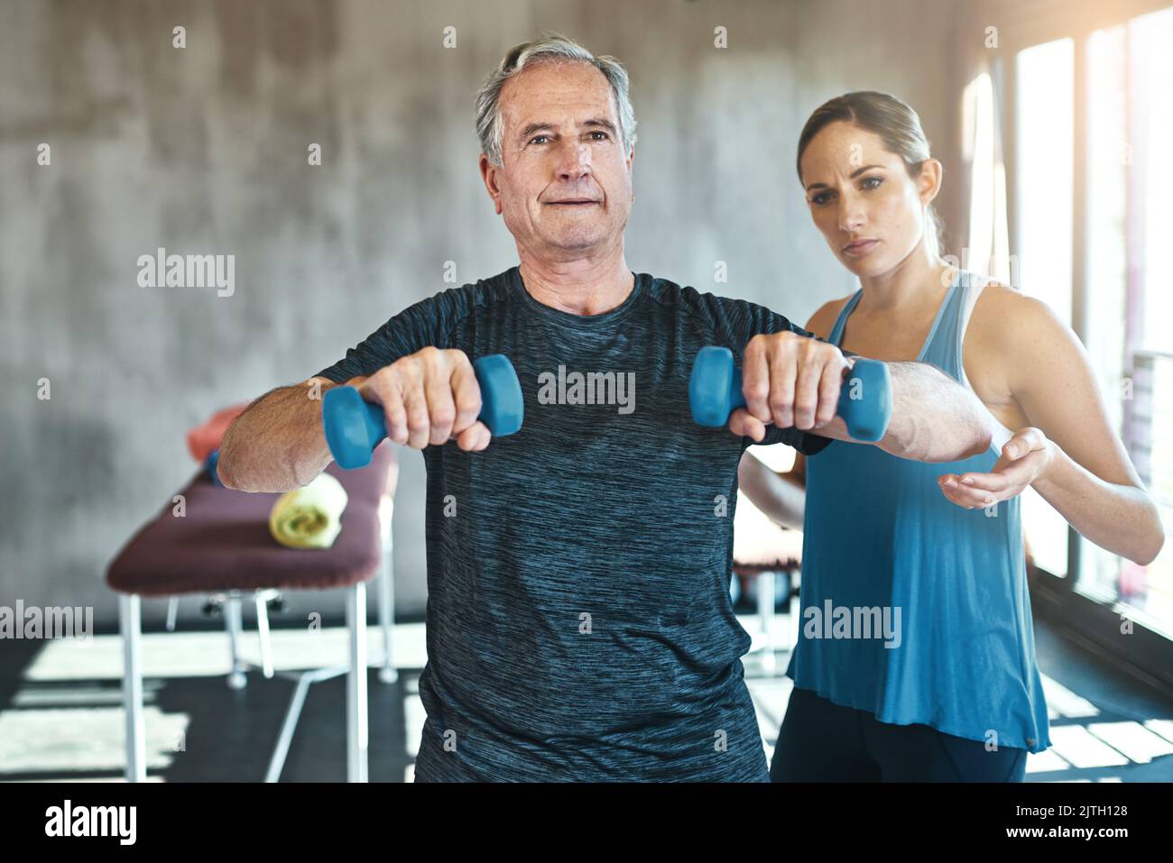 Staying fit in every stage of life. a senior man using weights with the ...