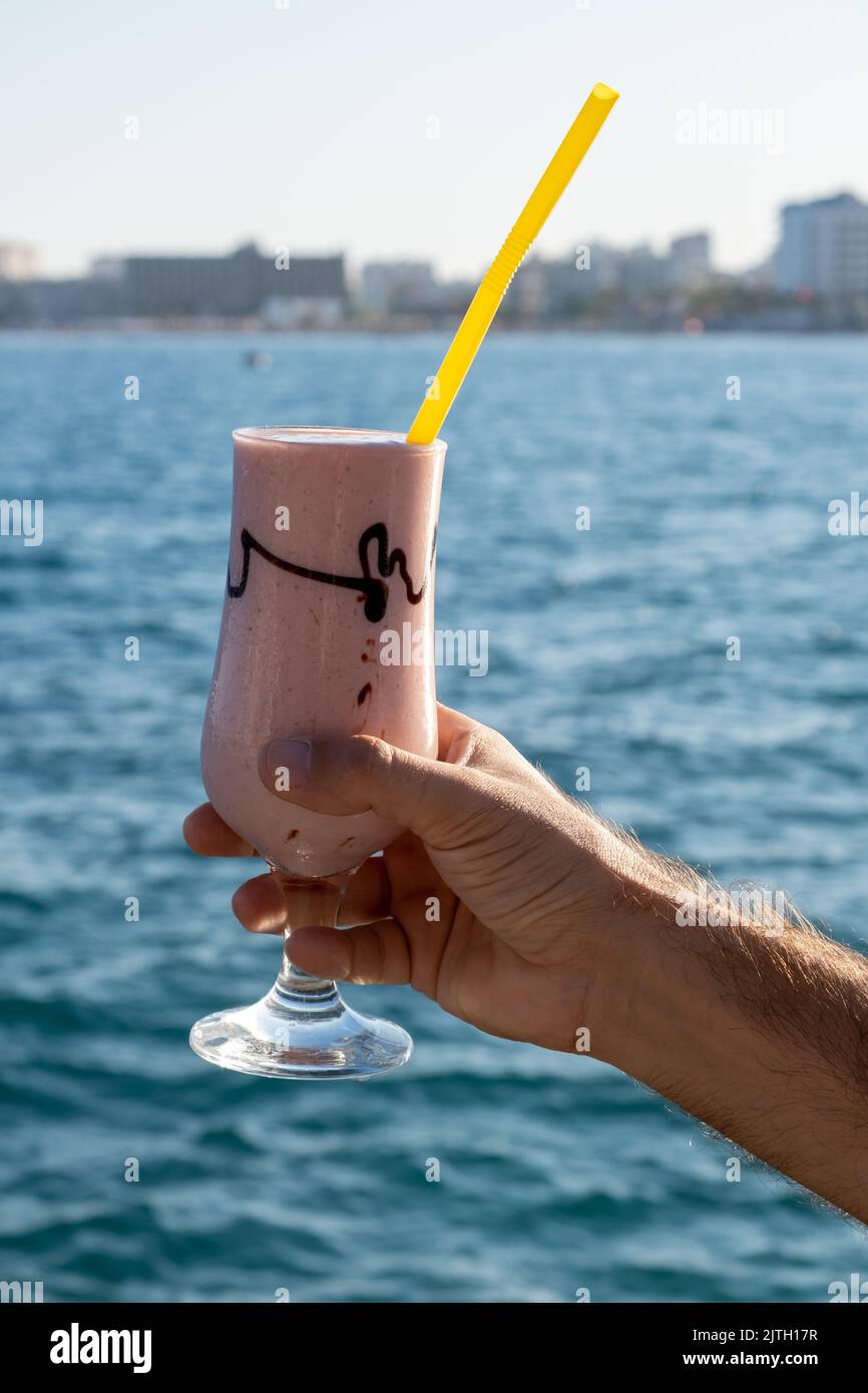 Close up first person view of male hand holding glass of cold icy ...