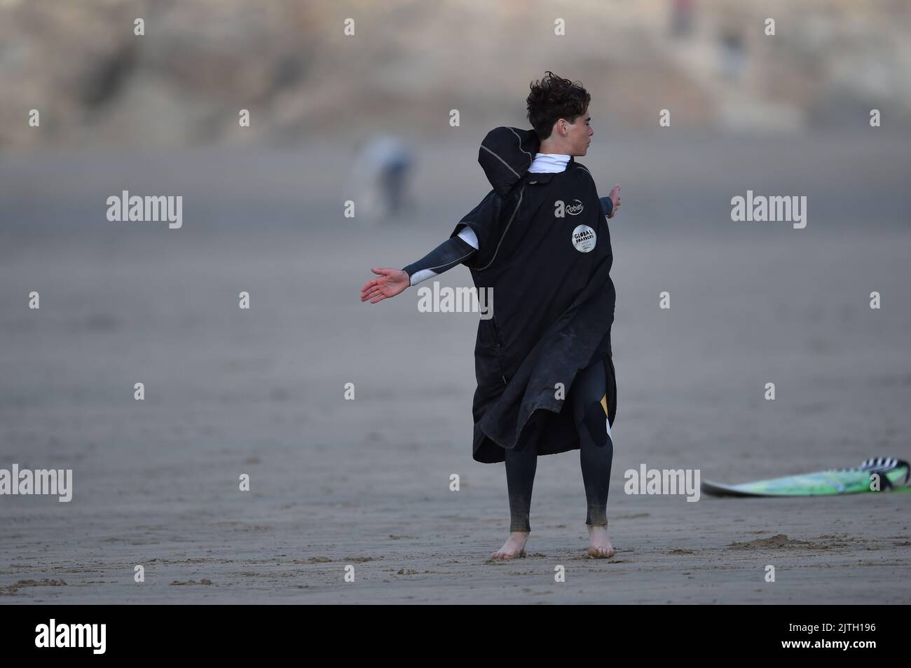 Surfer doing warm up exercises on beach before event Stock Photo - Alamy