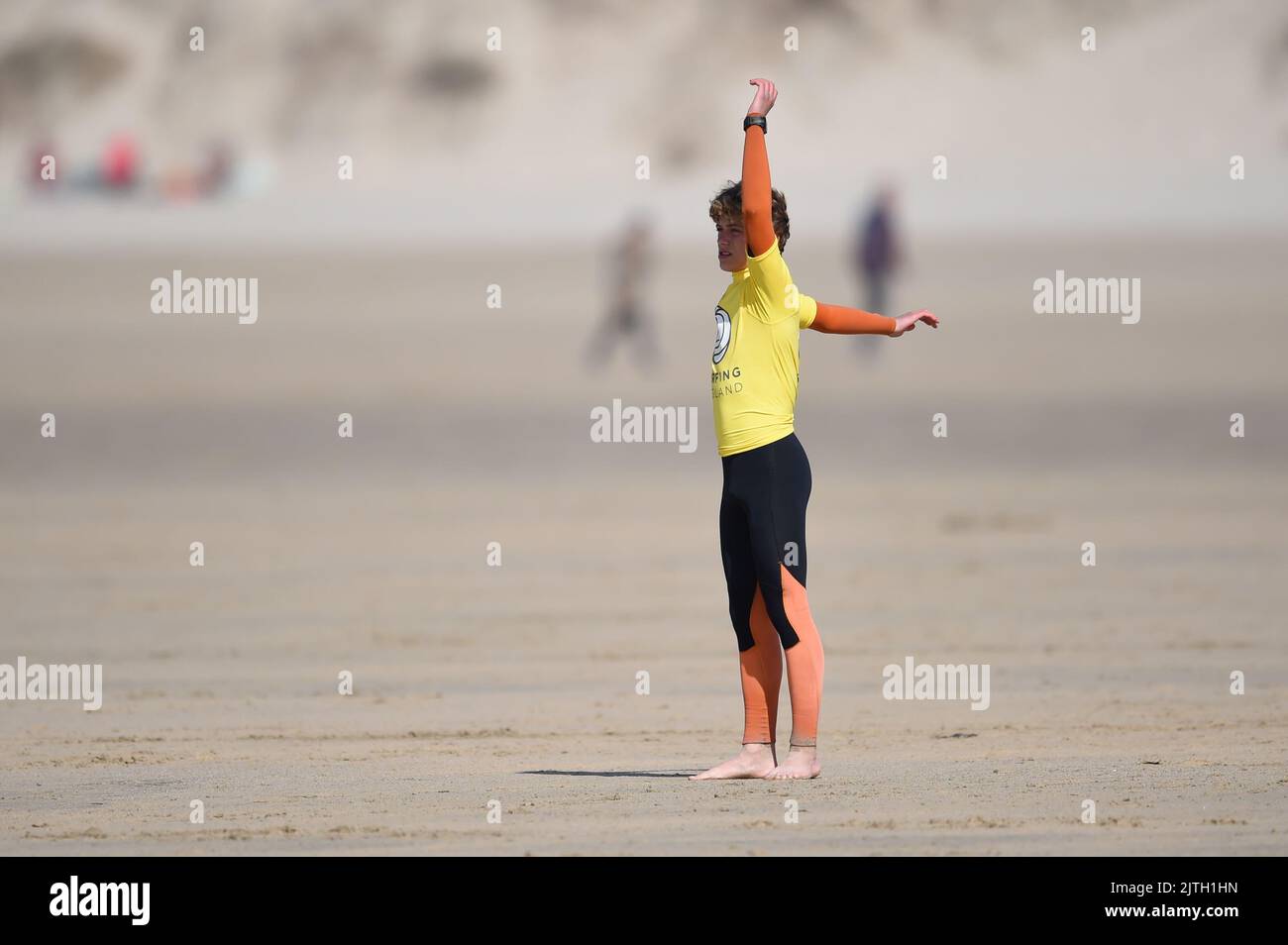 Surfer doing warm up exercises on beach before event Stock Photo - Alamy