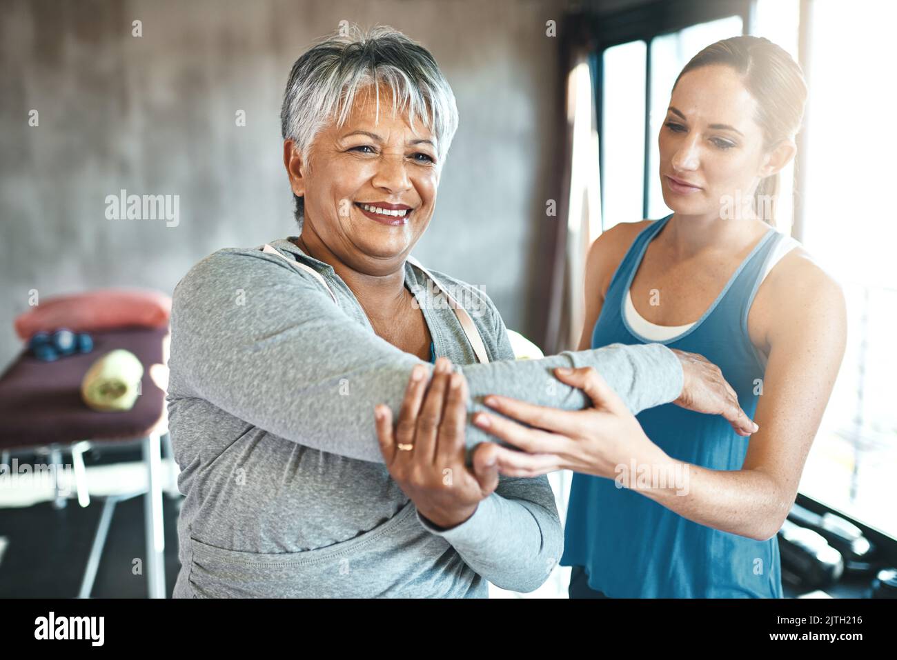 Staying fit improves her health and outlook on life. a senior woman working out with the help of ...