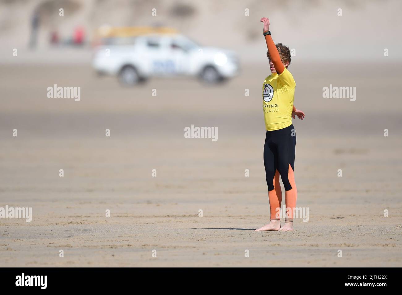 Surfer doing warm up exercises on beach before event Stock Photo - Alamy